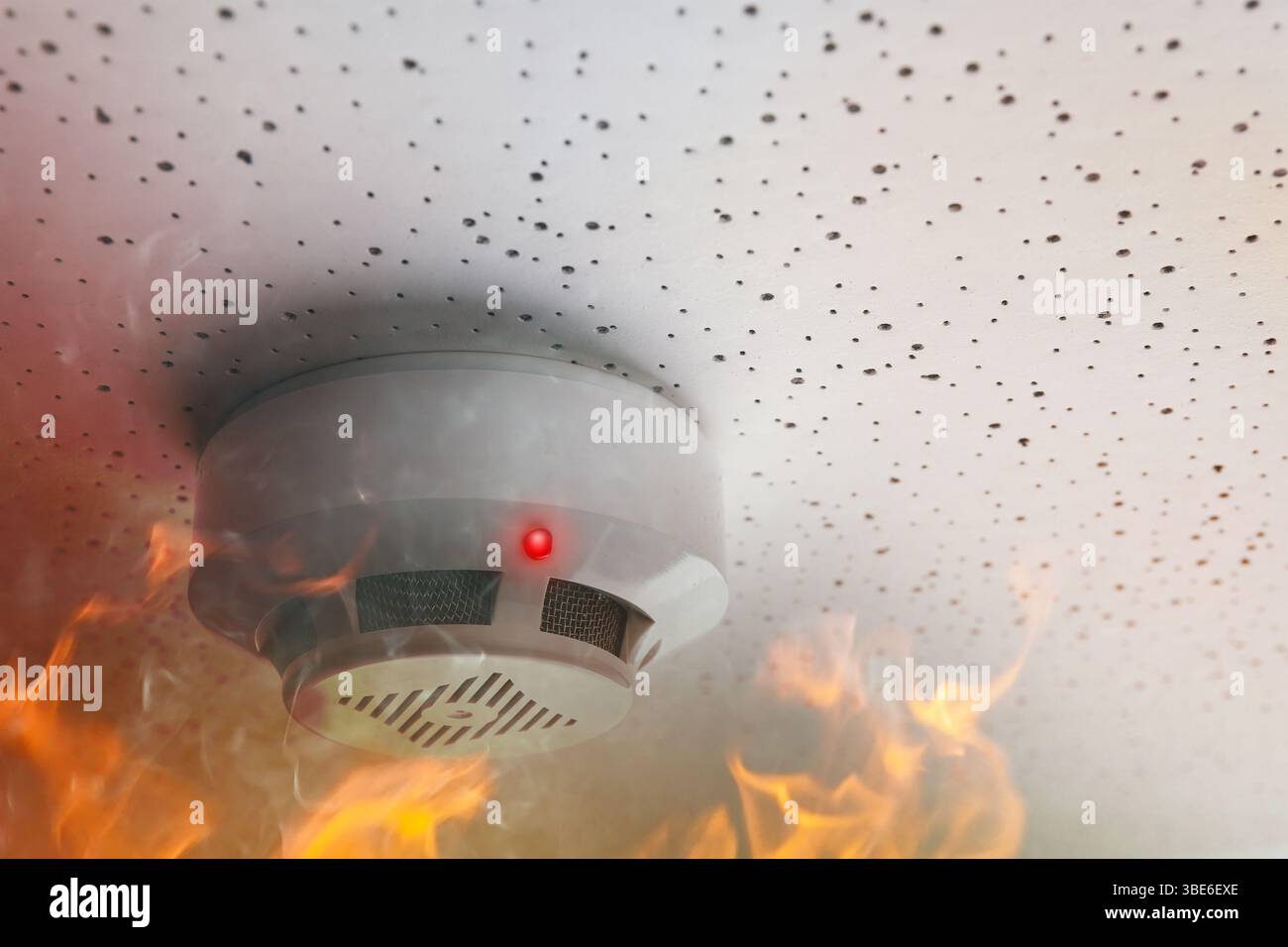 Fire alarm system. Detector on ceiling triggered by smoke and flame ...