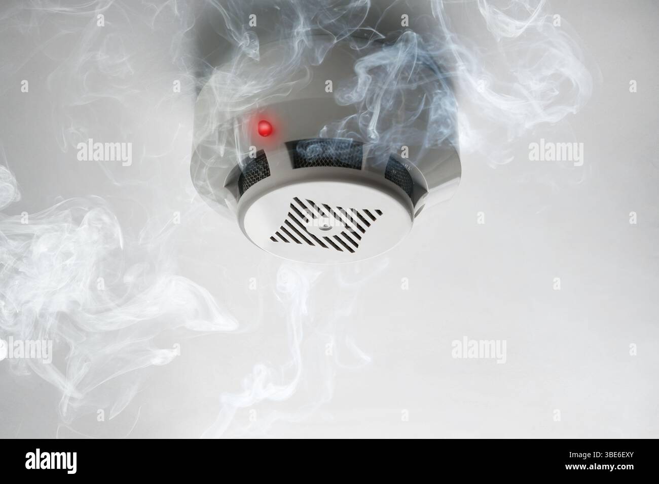 Fire alarm system detector on ceiling triggered by smoke Stock Photo ...