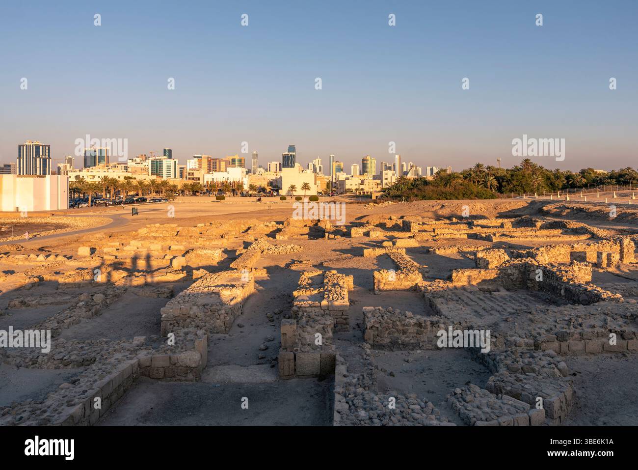 Archaeological ruins of Qalat al Bahrain in Manama with city skyline ...