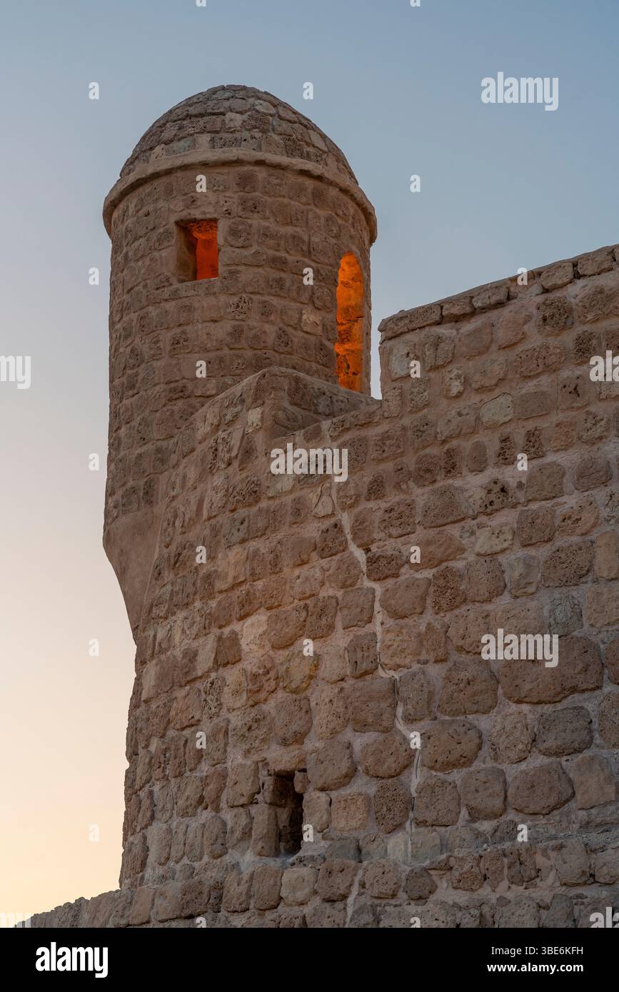 Tall stone turret and fortified wall dominate the evening view at Qalat ...