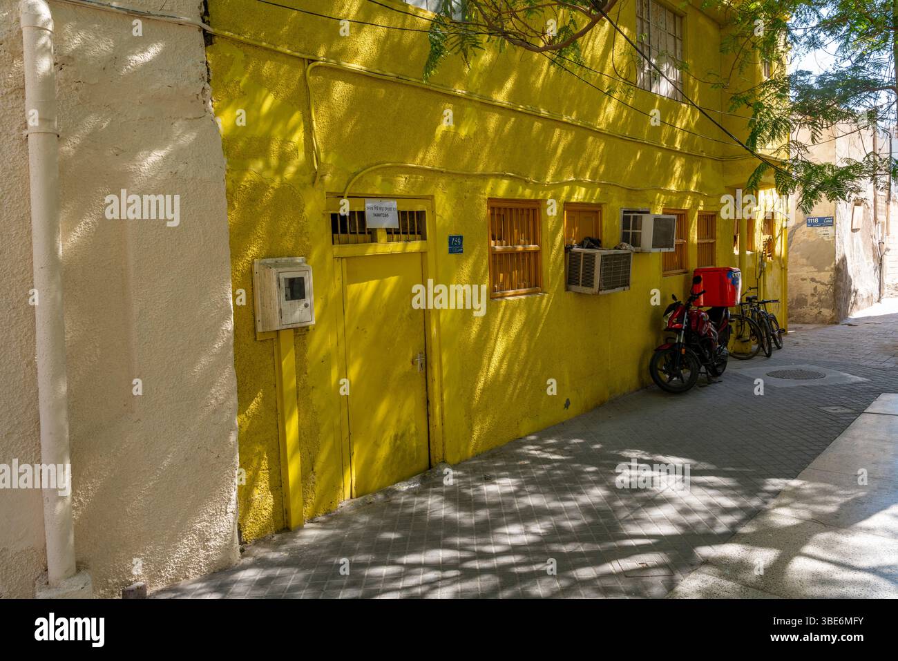 Bright yellow building with traditional windows creates colorful facade ...