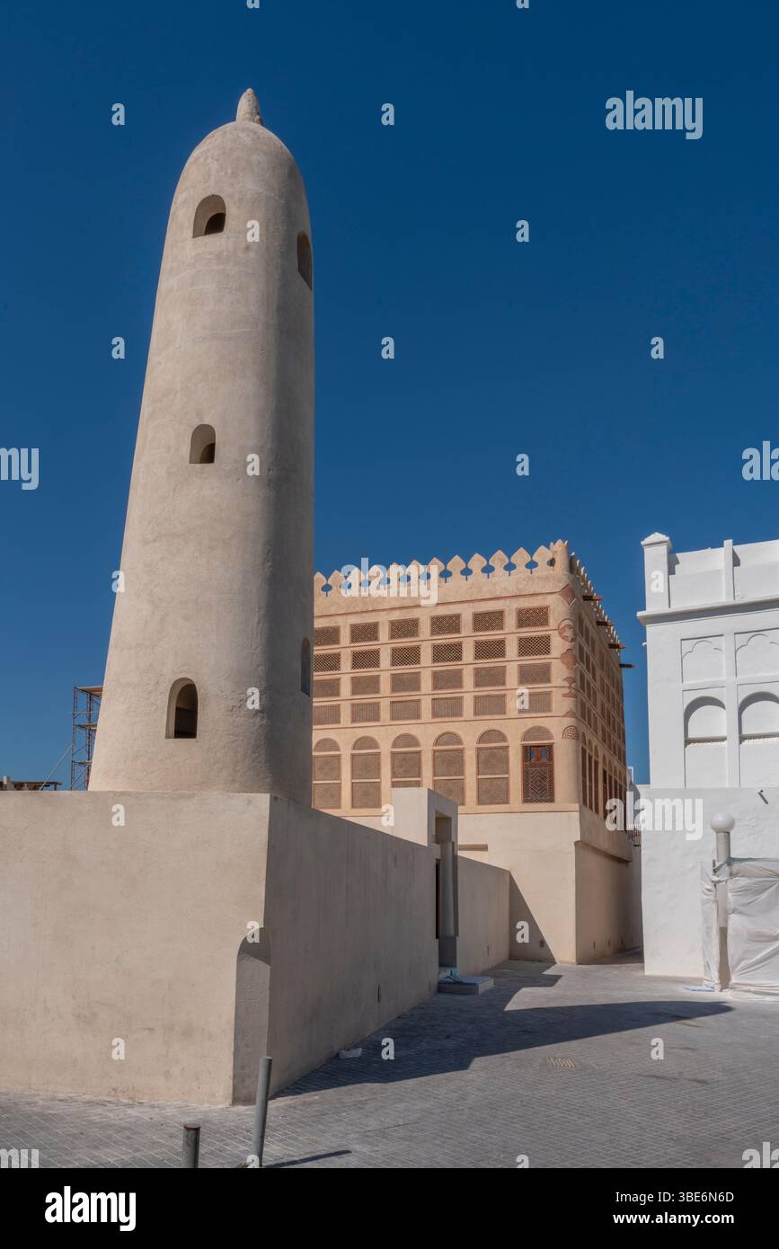 Traditional minaret tower rises beside modern buildings at Siyadi ...