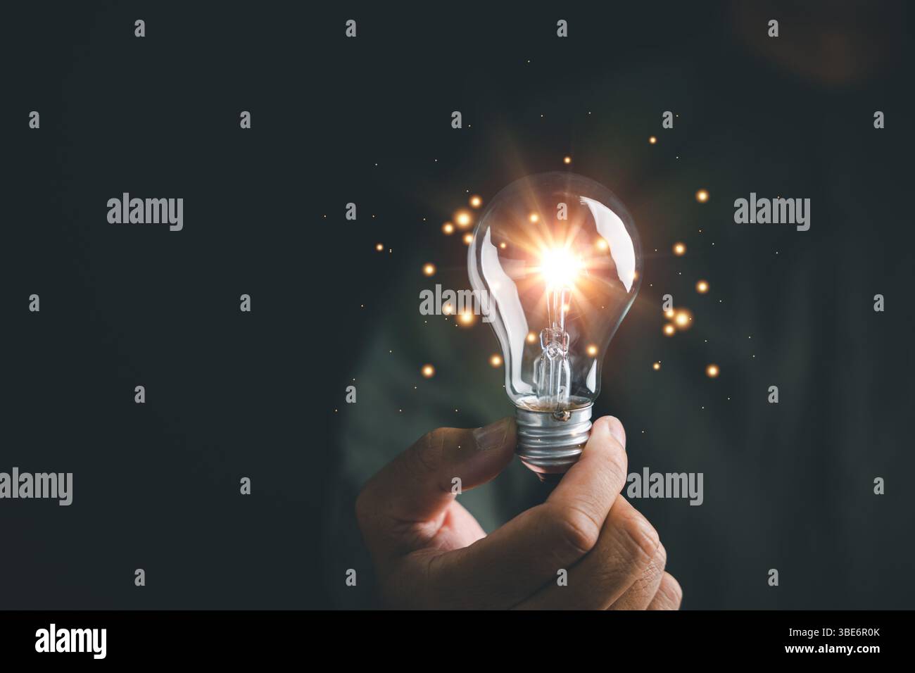 A hand holding a glowing light bulb, signifying the connection between ...