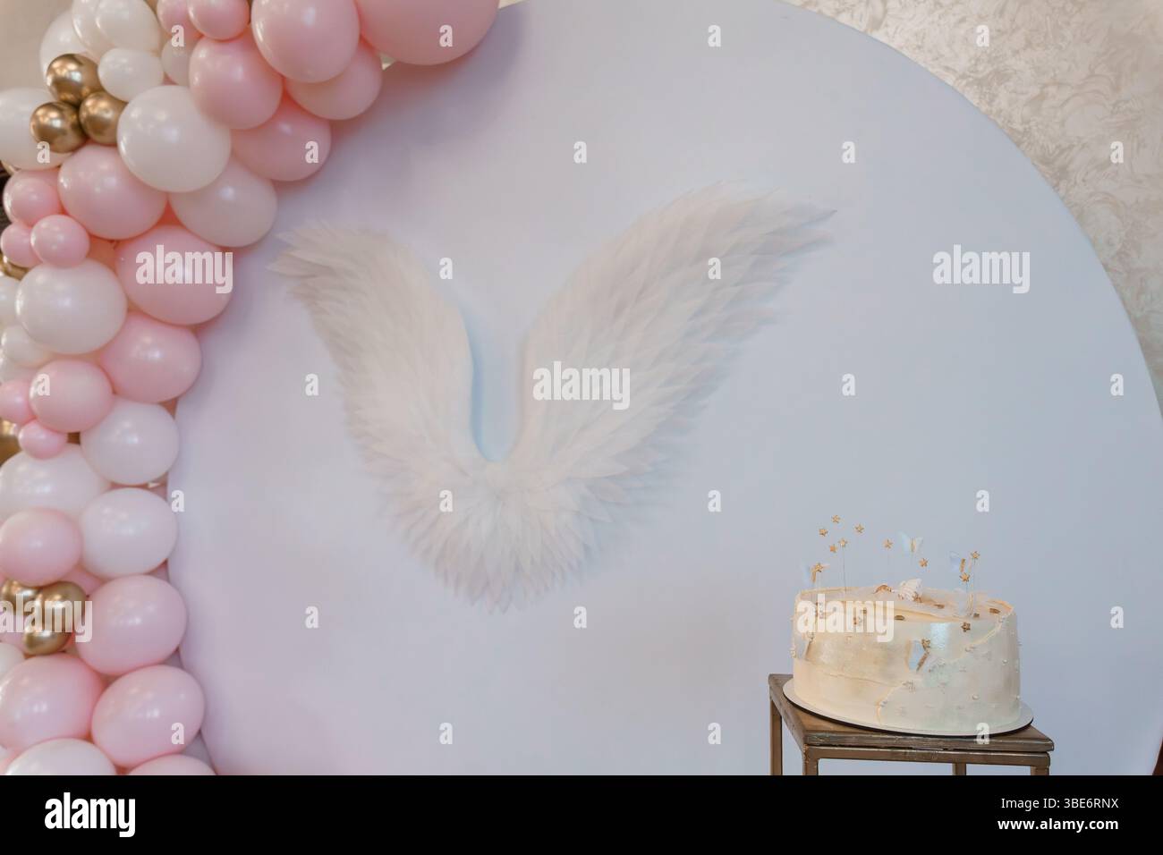 Angel-themed baby shower backdrop with pink and white balloon garland ...