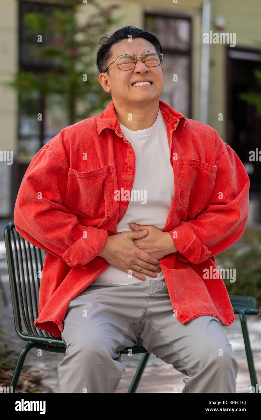Asian middle-aged man feeling sudden strong abdominal stomach ache ...