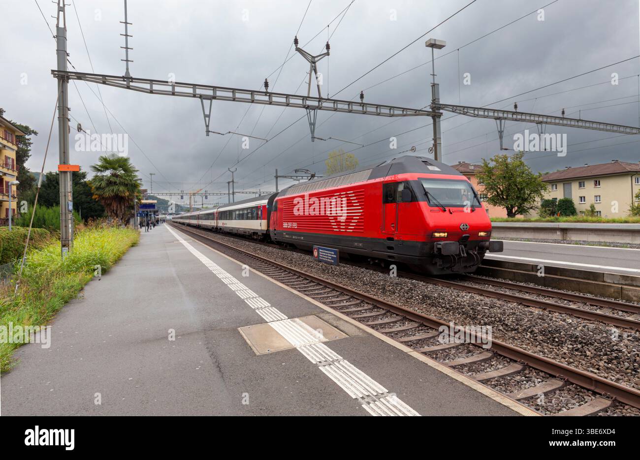 SBB Re 460 electric locomotive 460104 at Aigle railway station (Switzerland) with an intercity ...