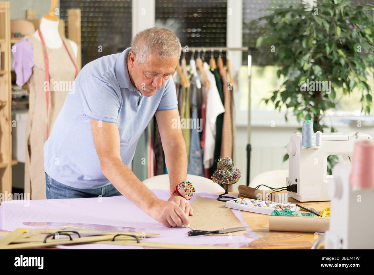 Senior man tailor draw dress pattern of product on paper Stock Photo ...