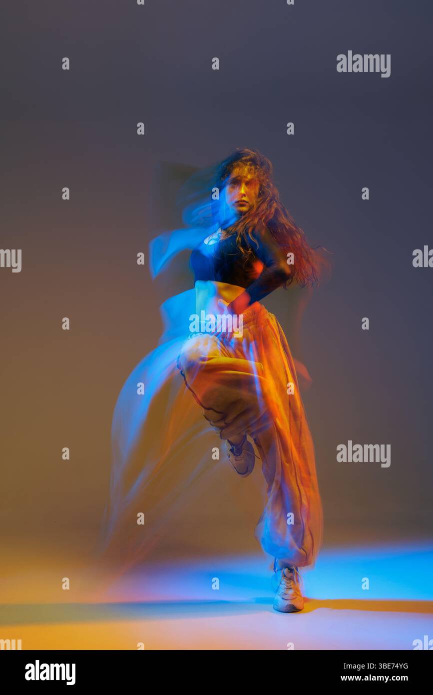 Female jazz-funk dancer in expressive pose with motion blur and vibrant ...