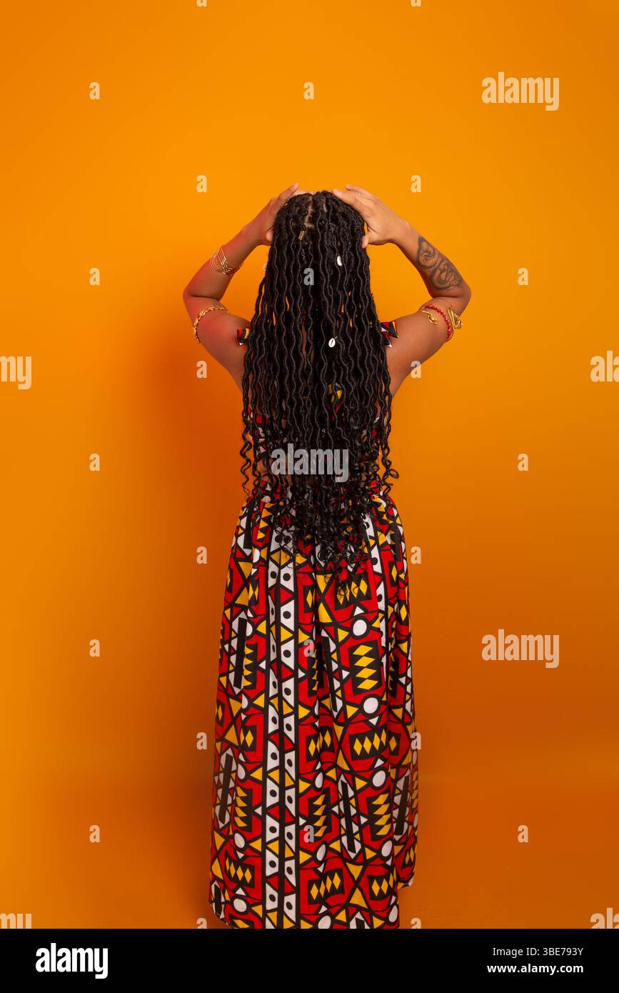 Beautiful young woman with braids in her hair, standing with her back ...