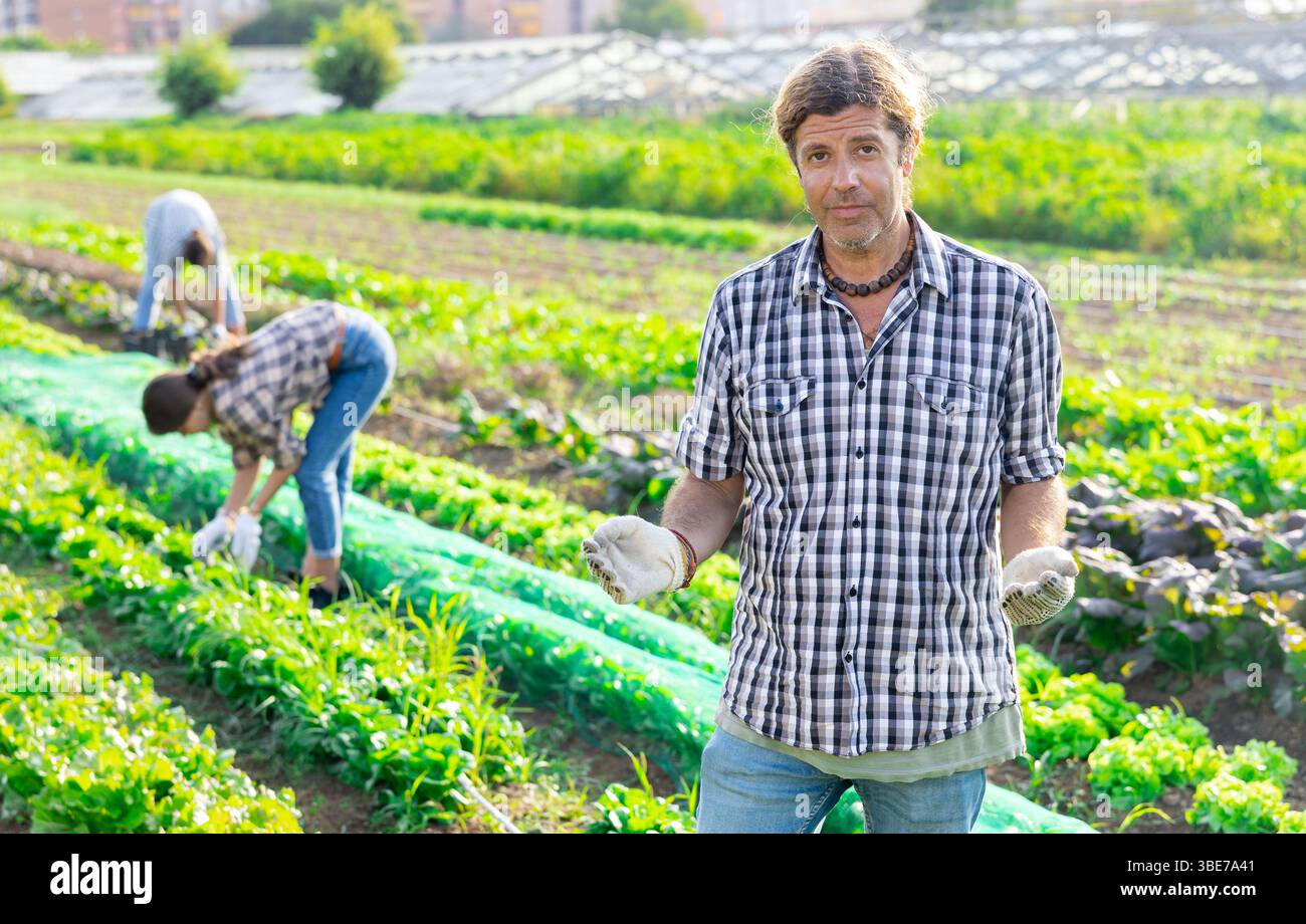 Portrait of positive farm owner against background of field with ...