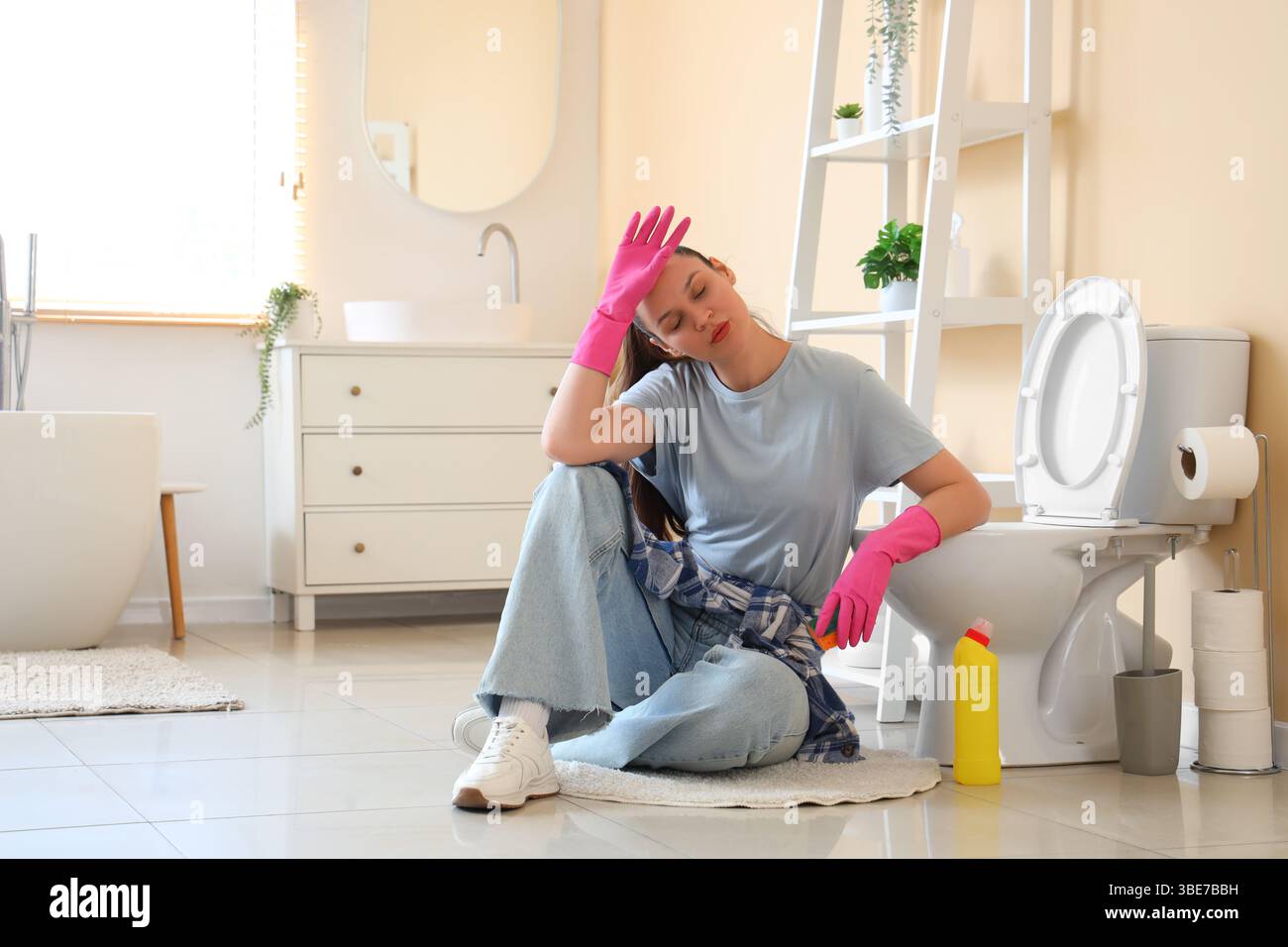 Tired young woman on floor after cleaning toilet in bathroom Stock ...