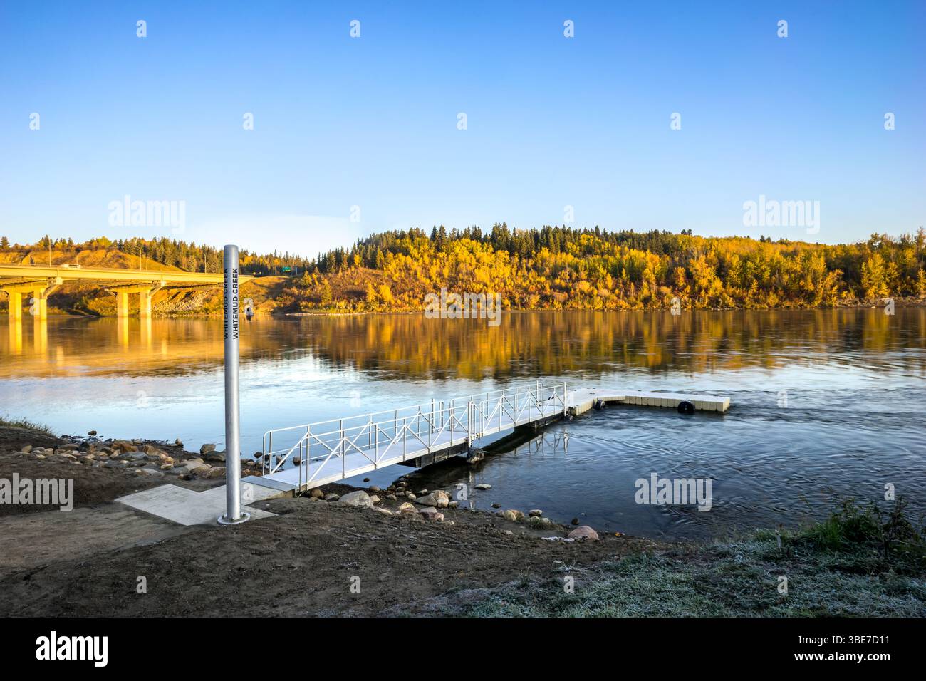 Whitemud Creek dock in early fall morning with a frost on grass and low ...