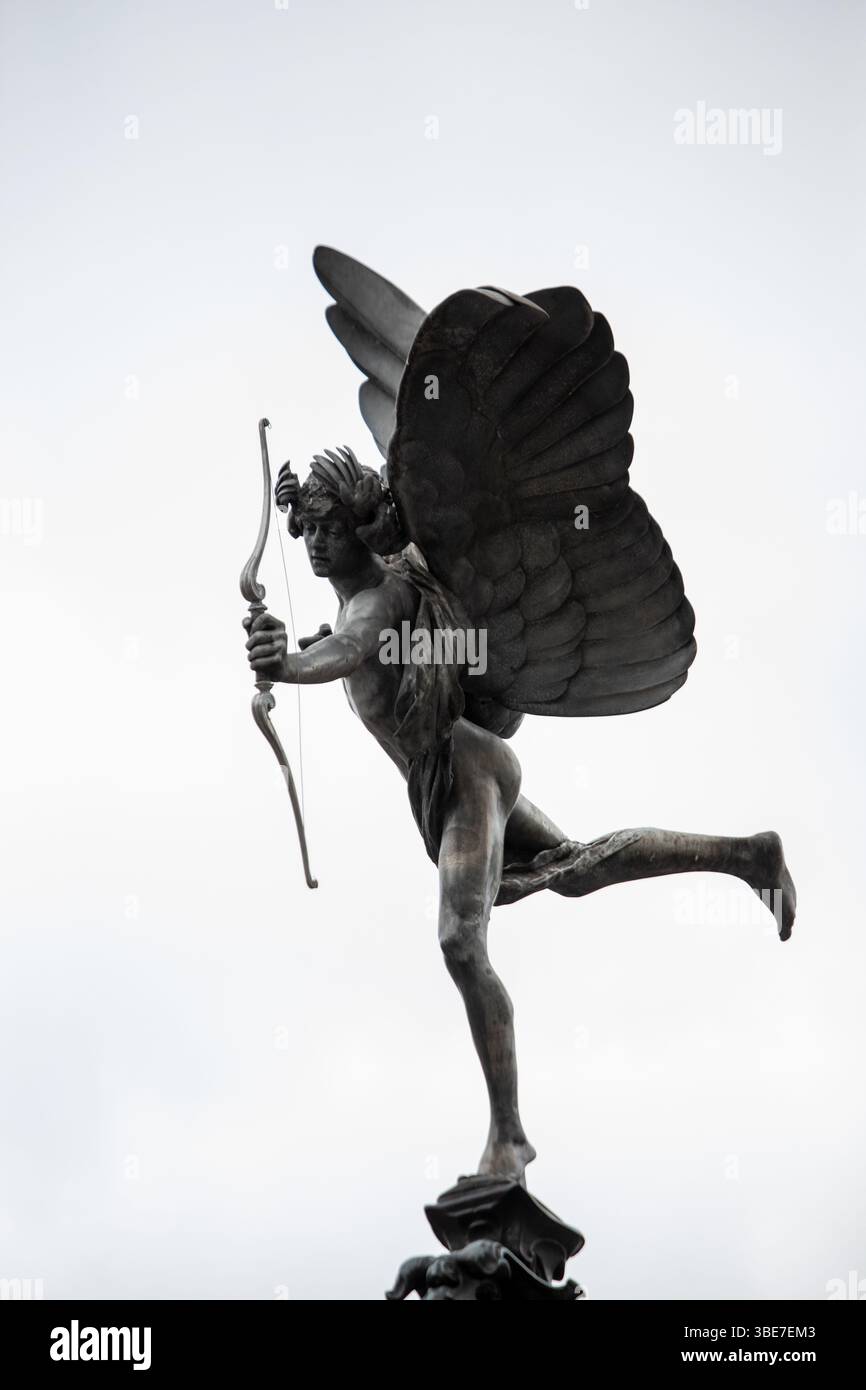A detailed view of a winged archer statue in London against a cloudy ...