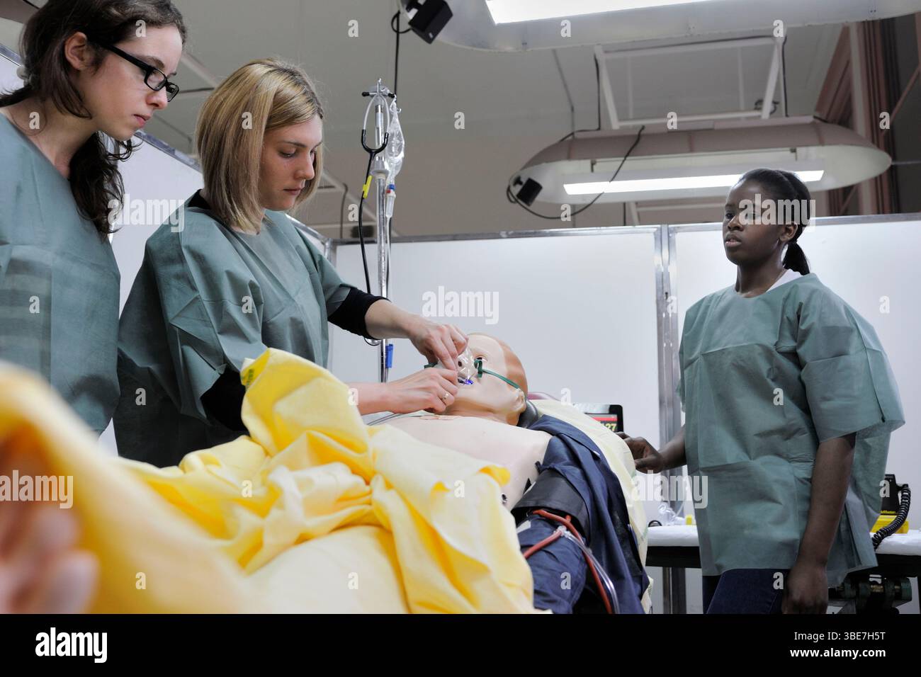 Student nurses training with a patient simulator mannequin ...