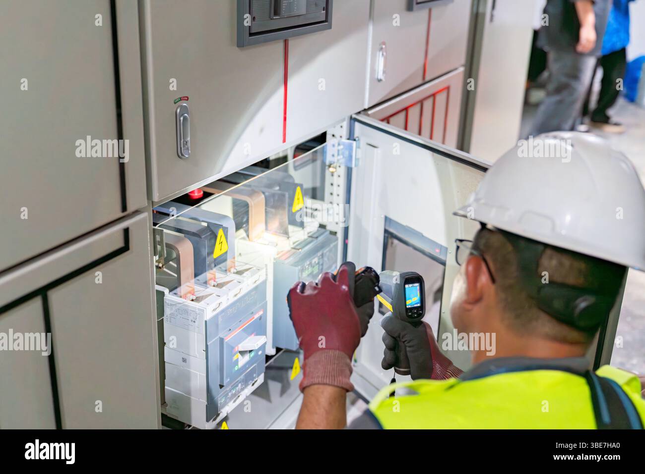Electric engineer use temp gun inspection main breaker for monitor ...