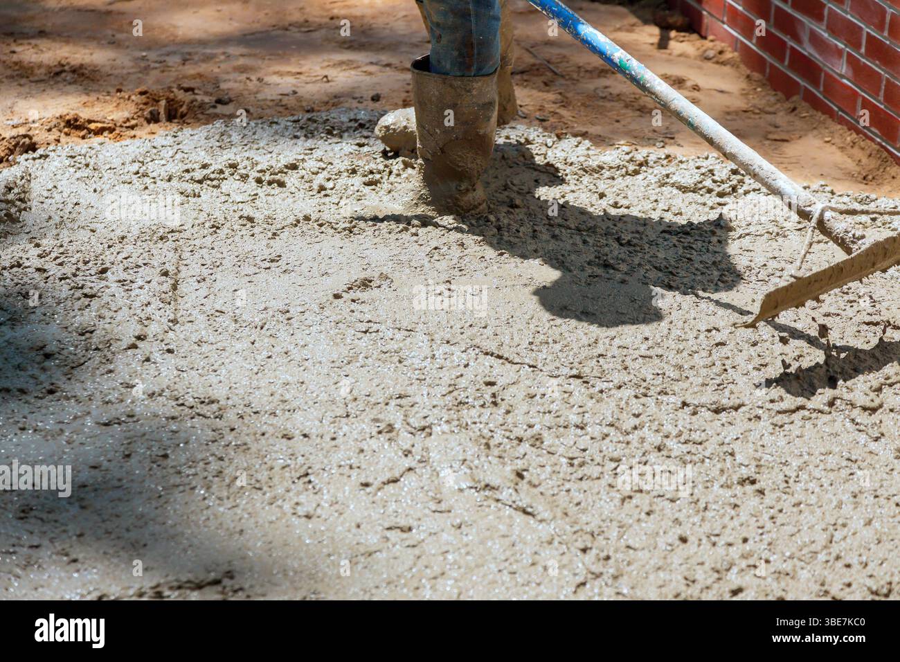 Construction workers are pouring, smoothing concrete mix on foundation ...