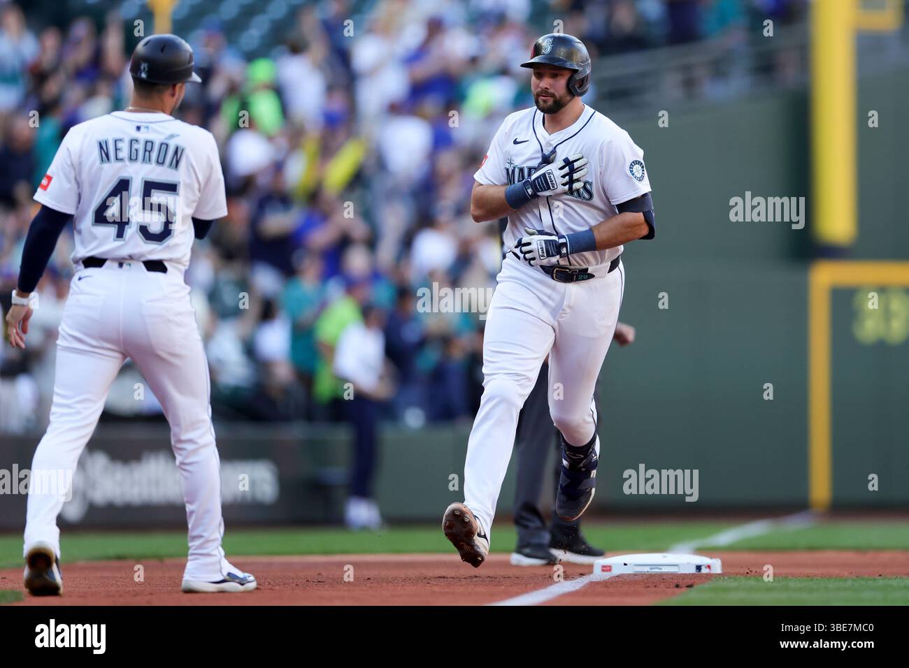 Seattle Mariners' Cal Raleigh, right, celebrates with third base coach ...