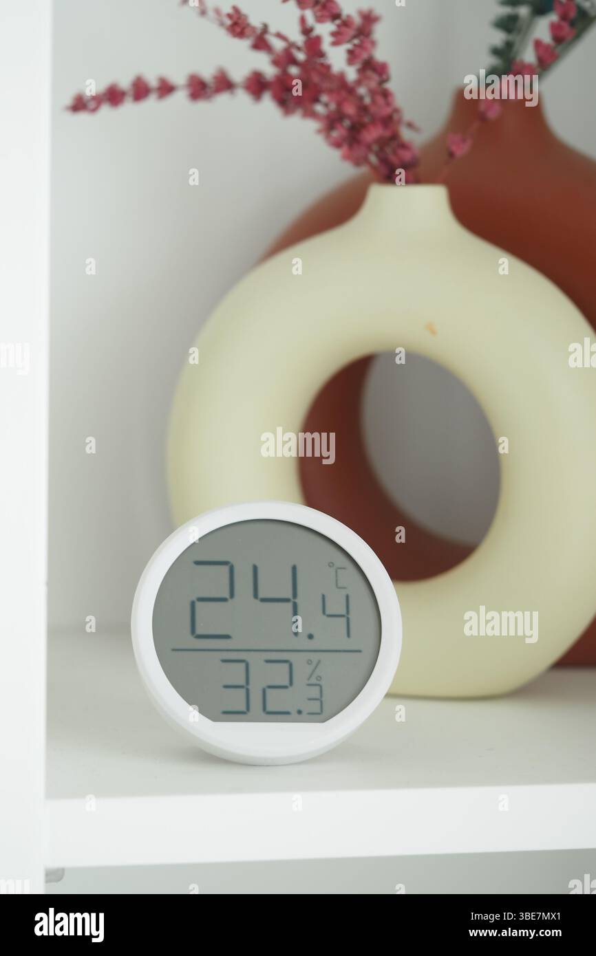 Indoor thermometer shows temperature and humidity on shelf Stock Photo ...