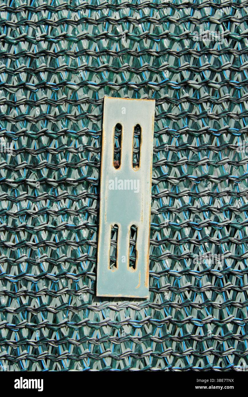 Metal fastener attaching a mesh shade cloth to a post Stock Photo - Alamy