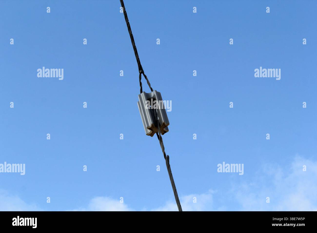 Insulator attached to a power electricity line cable with a blue sky ...