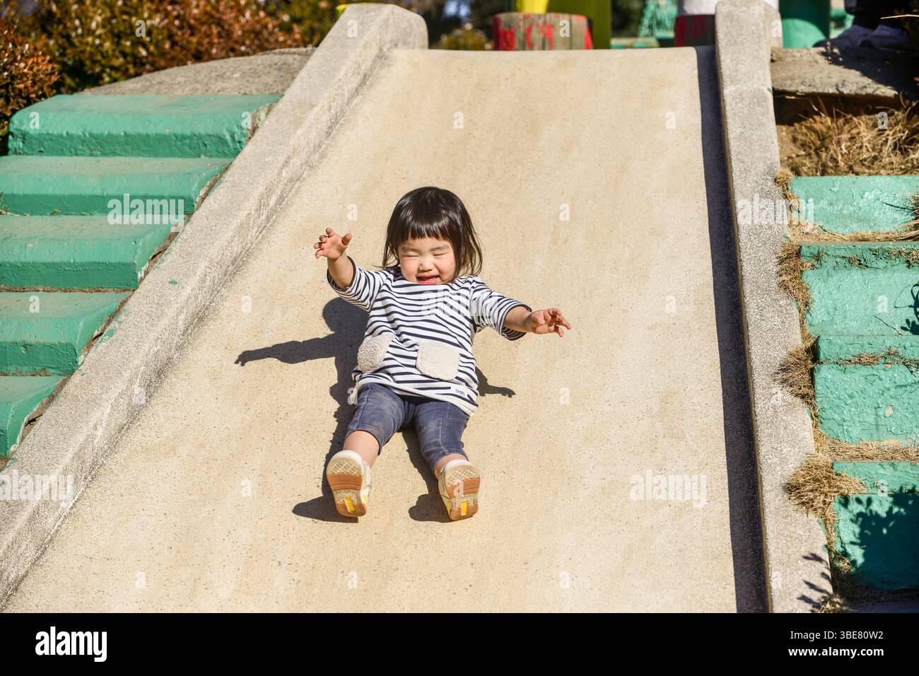 Toddler playing on the slide Stock Photo - Alamy
