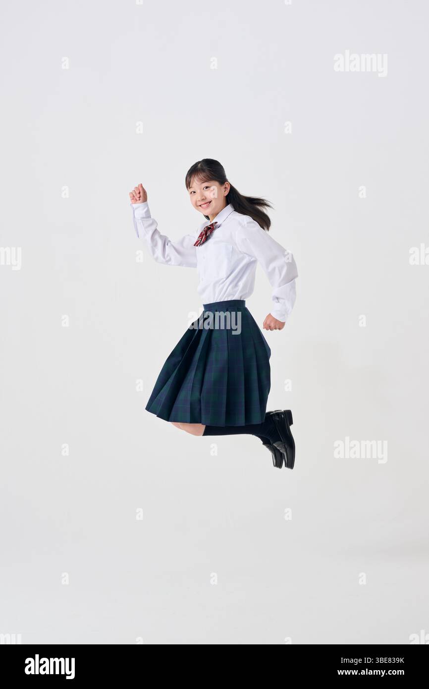Japanese Junior High School Girl Jumping with a Smile on White ...