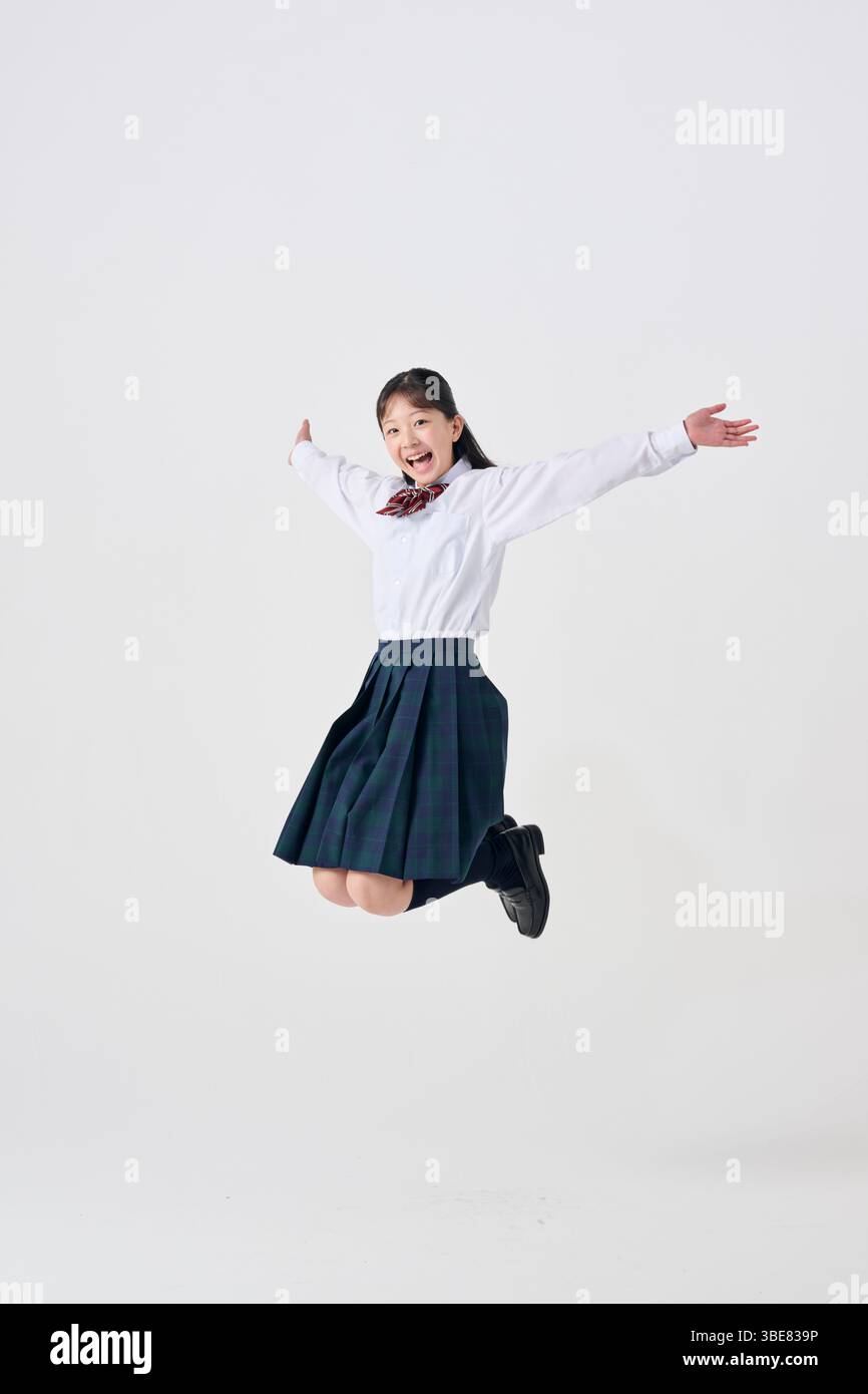 Japanese Junior High School Girl Jumping with a Smile on White ...