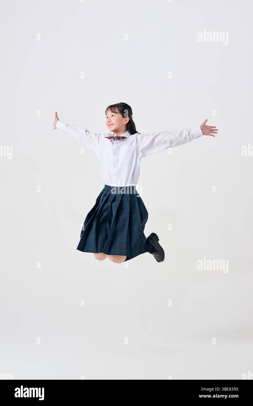 Japanese Junior High School Girl Jumping with a Smile on White ...
