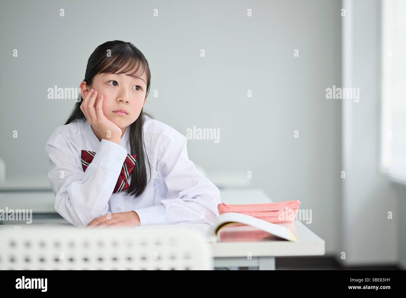 Junior high school girls thinking in a classroom Stock Photo - Alamy