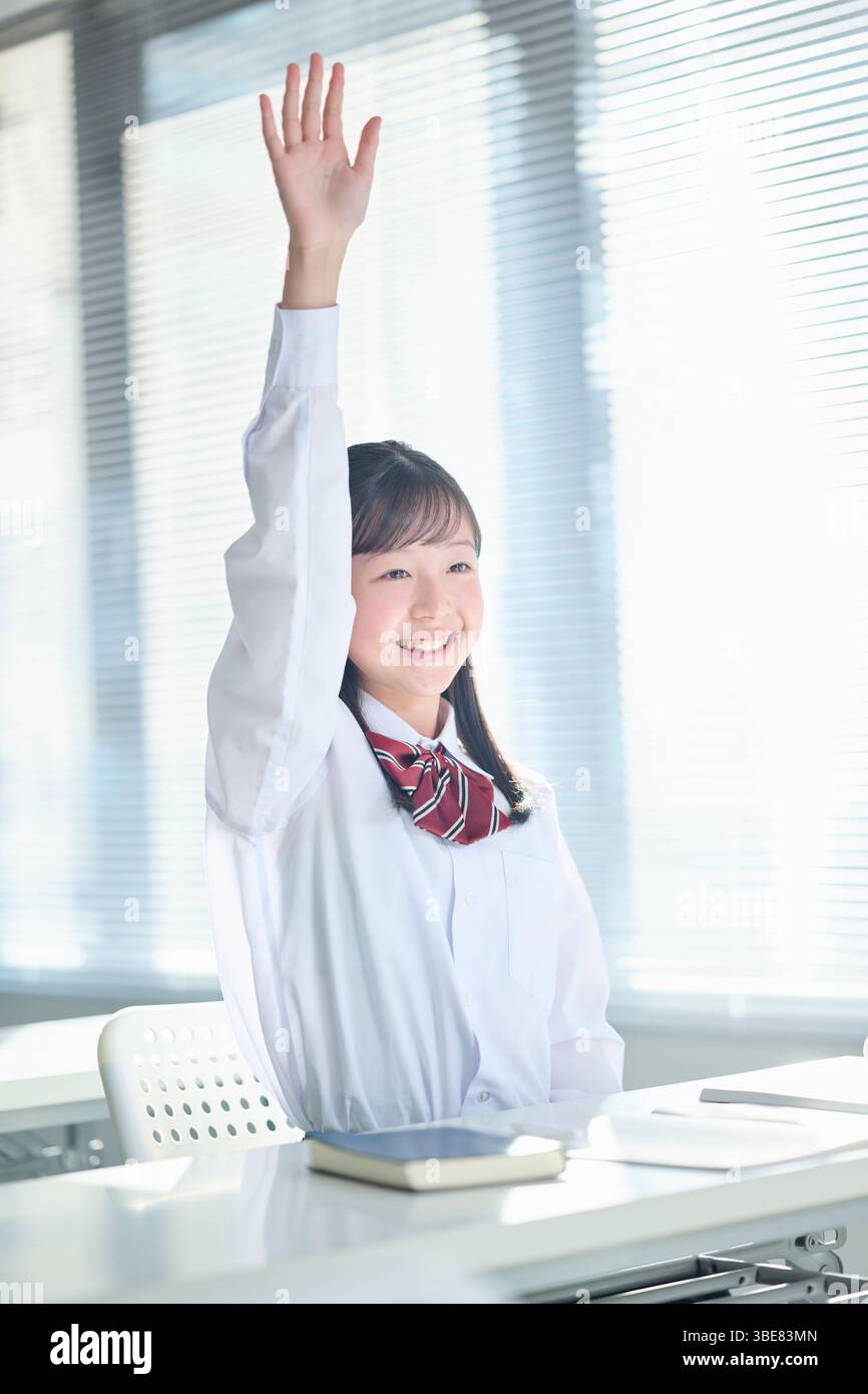 Junior high school girls raising their hands in class Stock Photo - Alamy