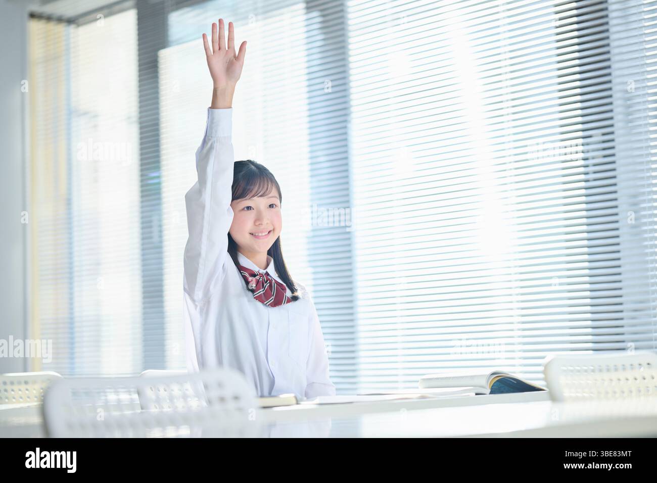 Junior high school girls raising their hands in class Stock Photo - Alamy