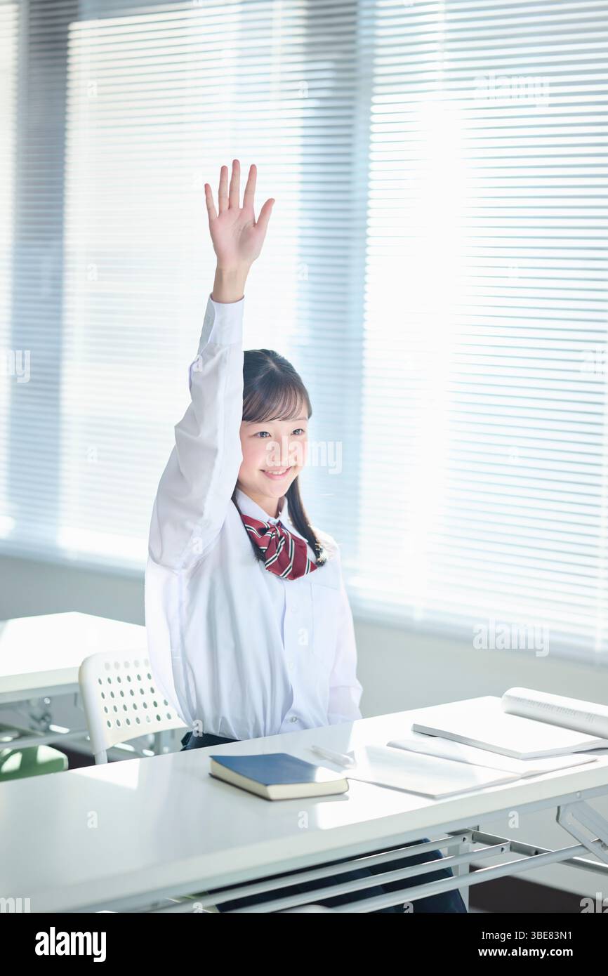 Junior high school girls raising their hands in class Stock Photo - Alamy