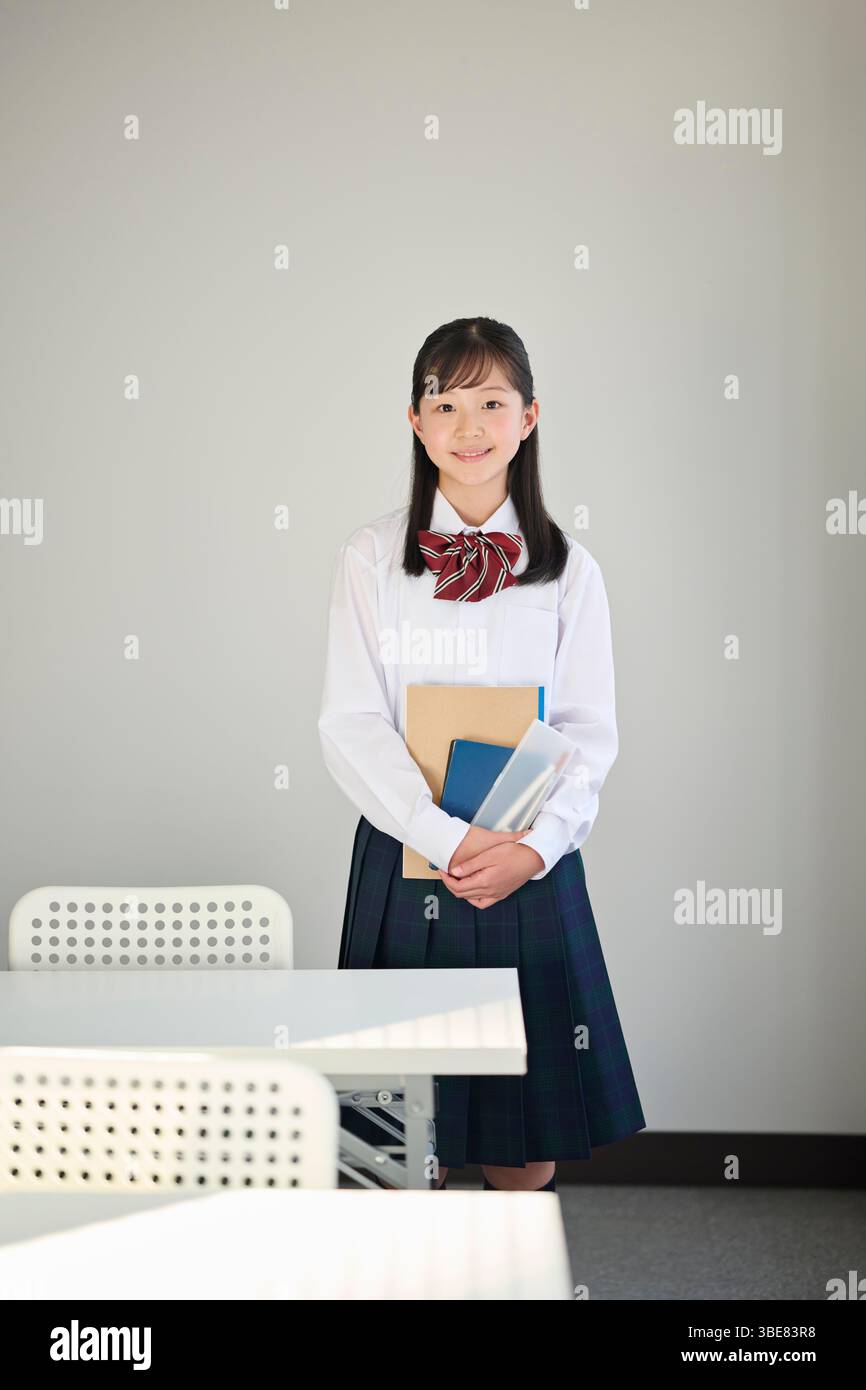 Junior high school girl with teaching materials in the classroom ...
