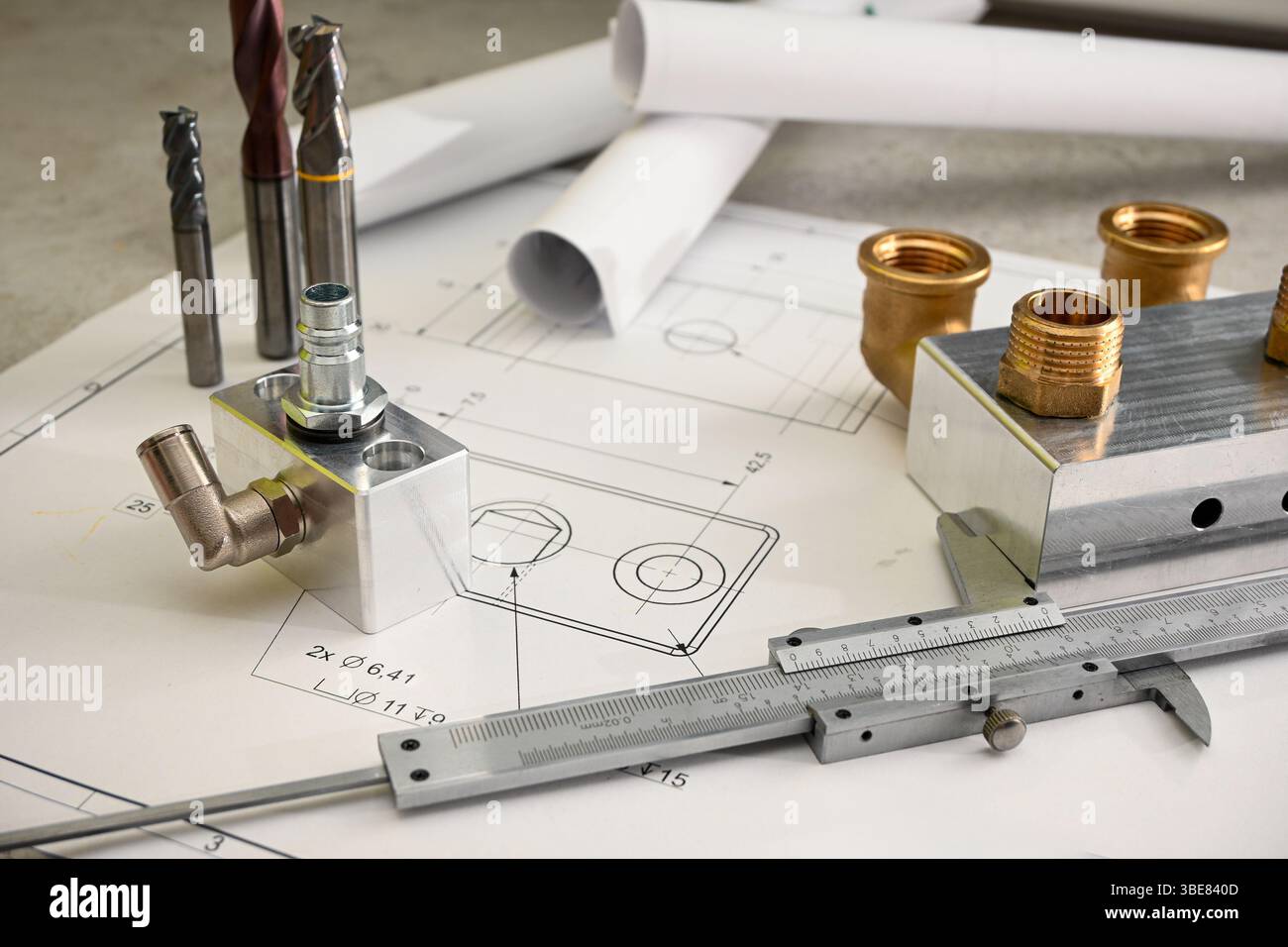 Metal machined components, caliper, and end mill cutters lying on a ...