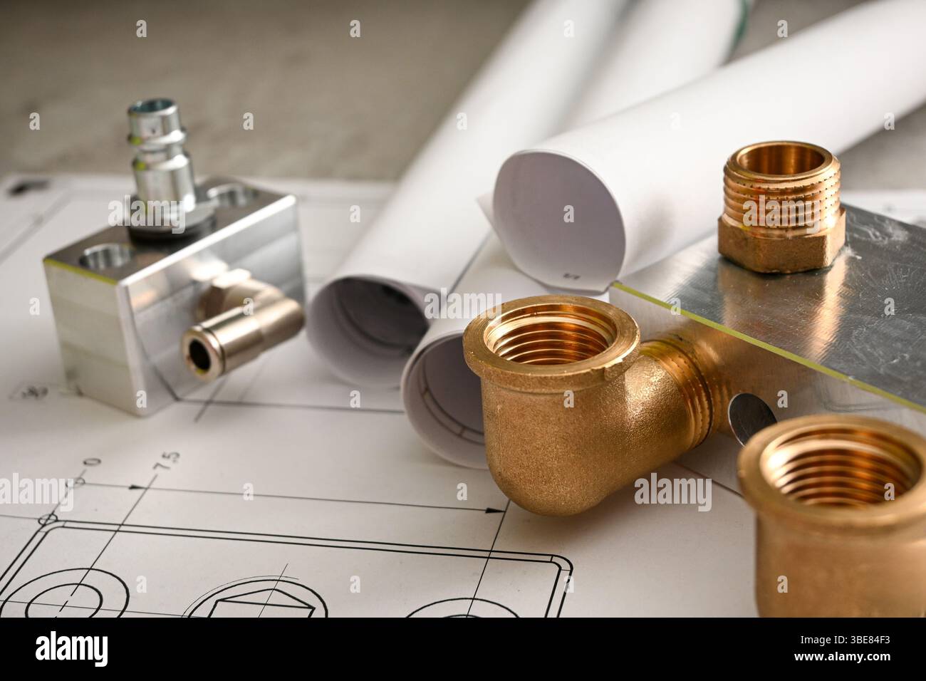 Plumbing fixtures and rolled blueprints lie on a technical drawing, showcasing building or ...
