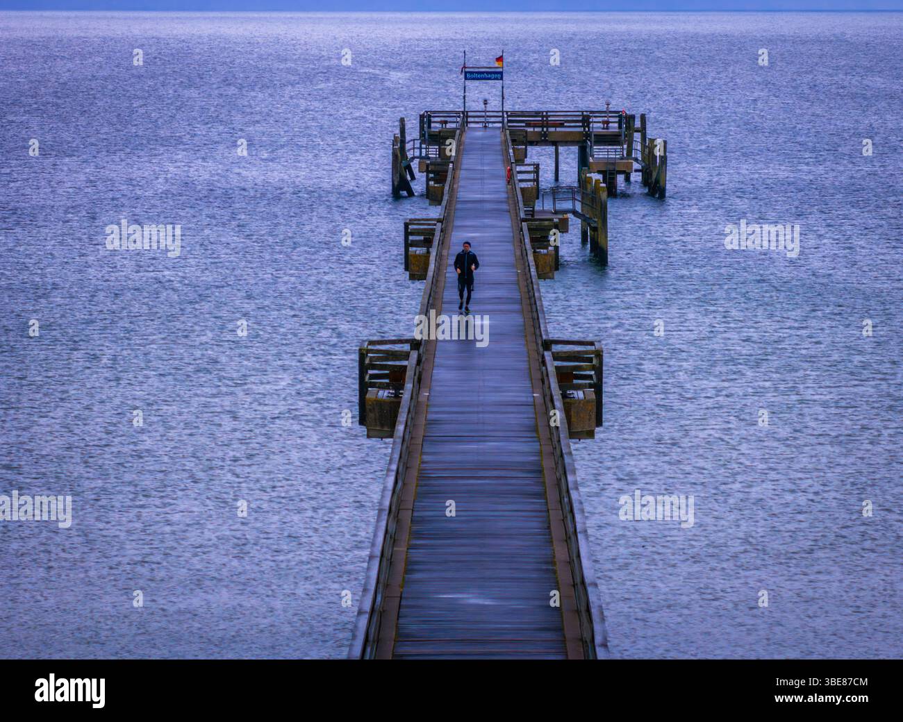 Boltenhagen, Germany. 28th May, 2025. A man jogs across the pier on the ...