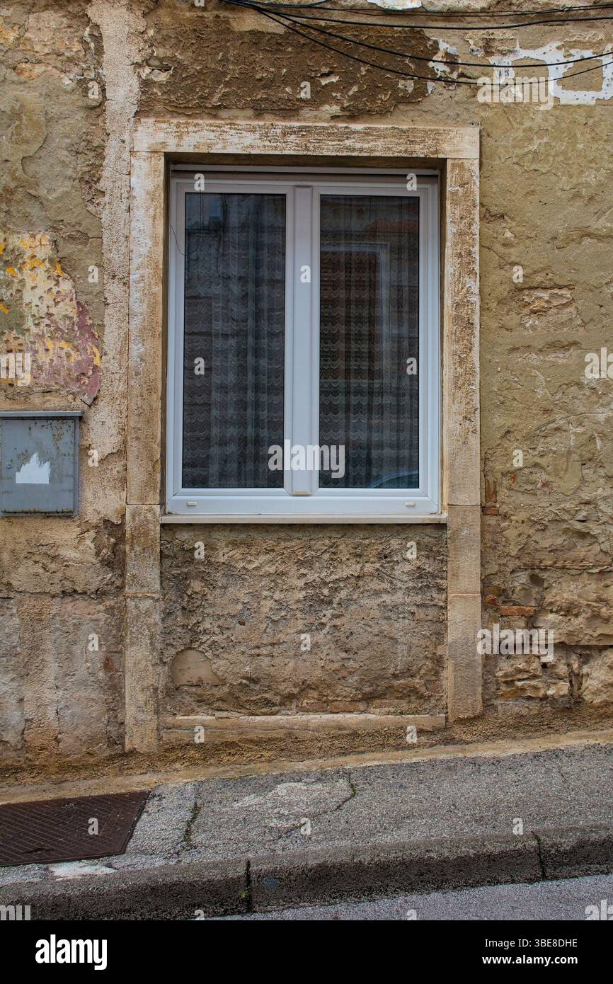 A modern UPVC window installed inside what was originally a stone door ...