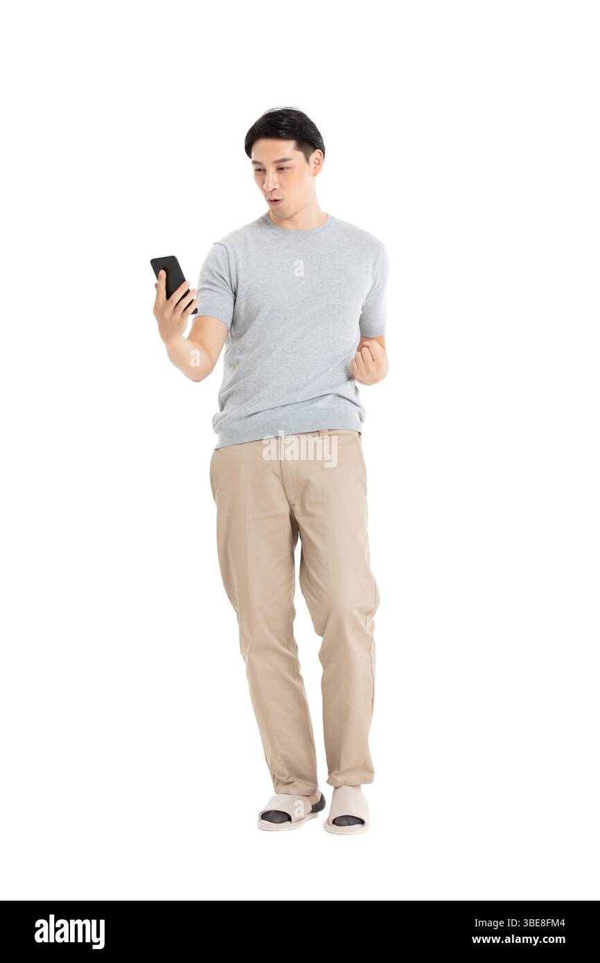 A young man staring at his phone screen, absolutely thrilled with his ...