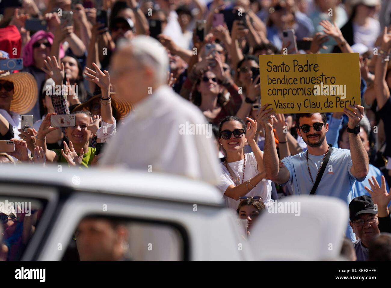 A couple holds a banner reading in Spanish language 'Holy Father bless ...