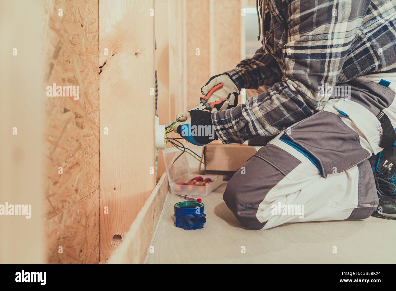 A skilled electrician works on wiring installation within a residential ...
