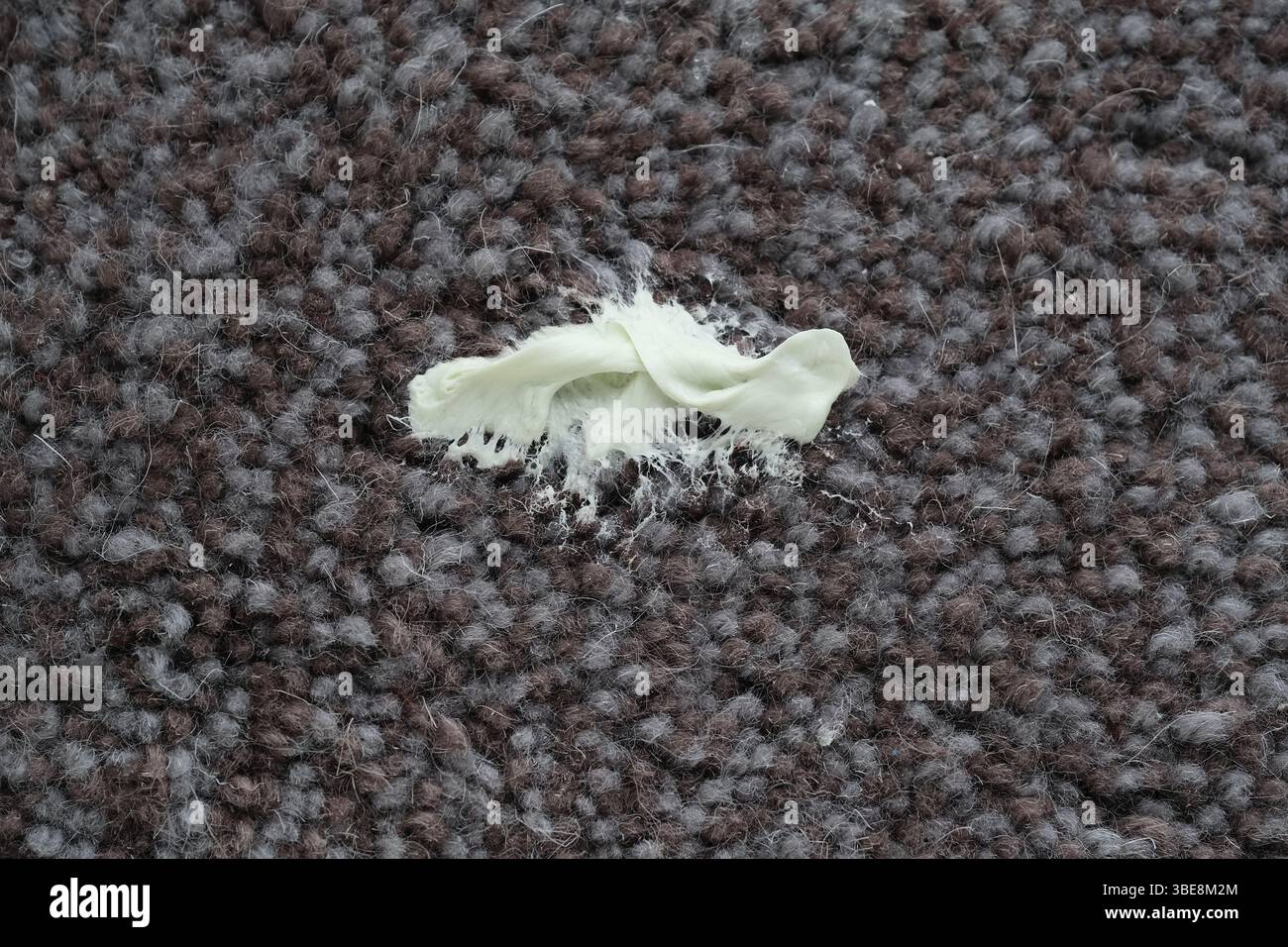 Sticky substance stretching on gray textured carpet. removing chewing ...