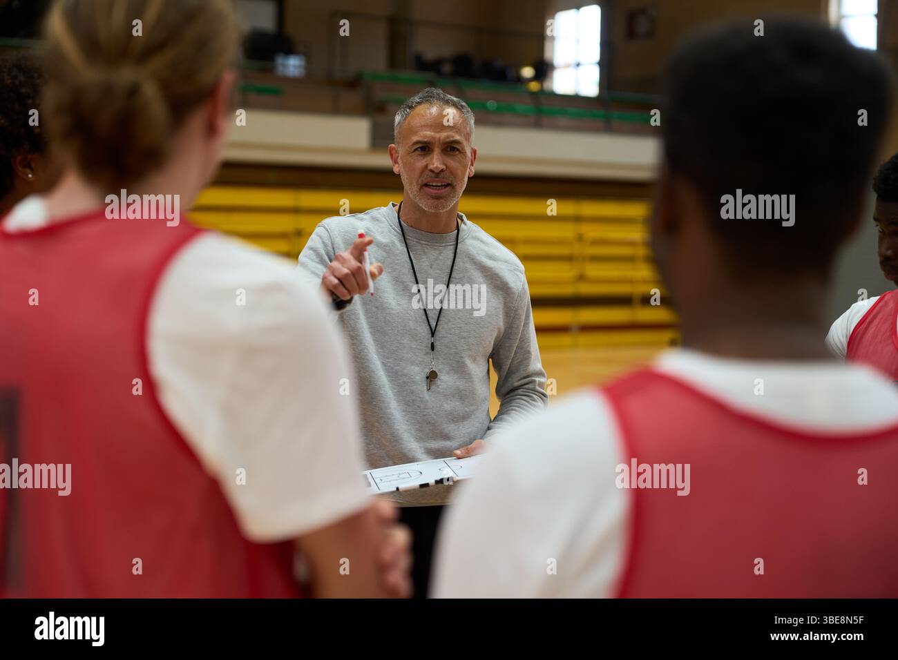 Basketball coach explaining strategy to team during timeout Stock Photo ...