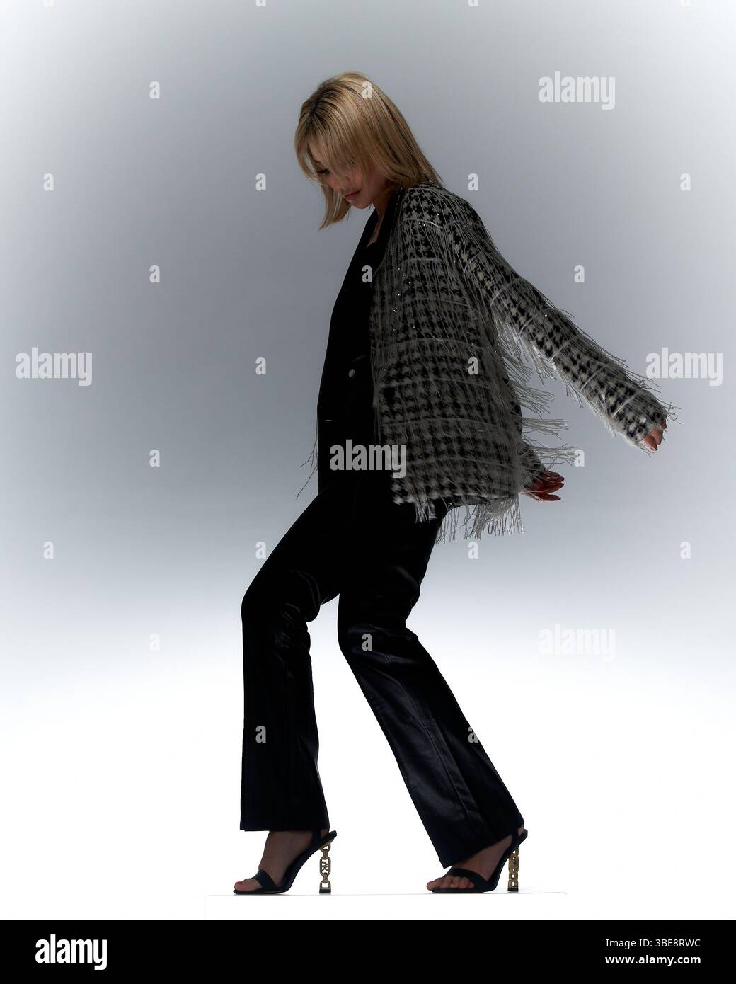 Blonde woman walking in side profile wears black and white fringe ...