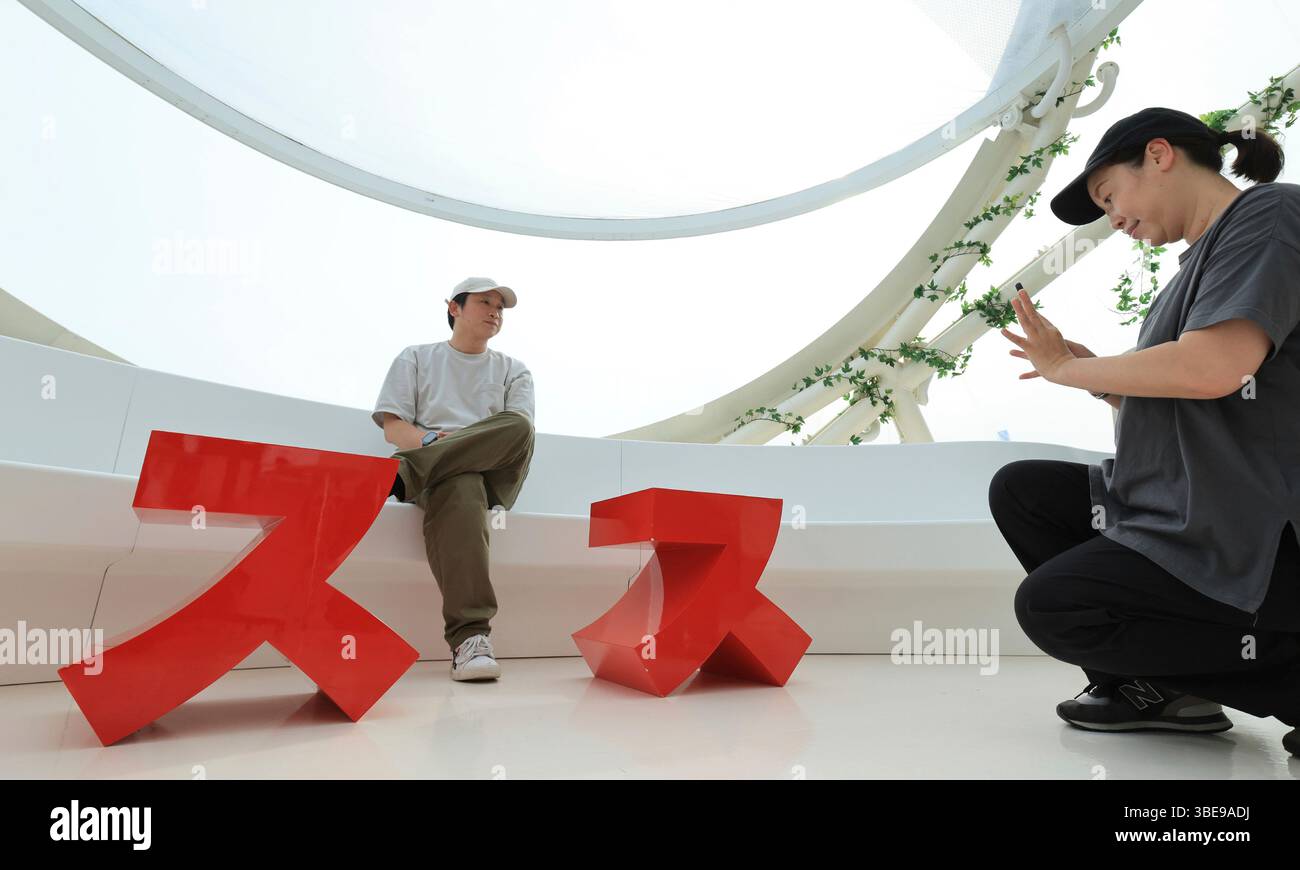 A man crosses his legs in the shape of the Japanese katakana character ...