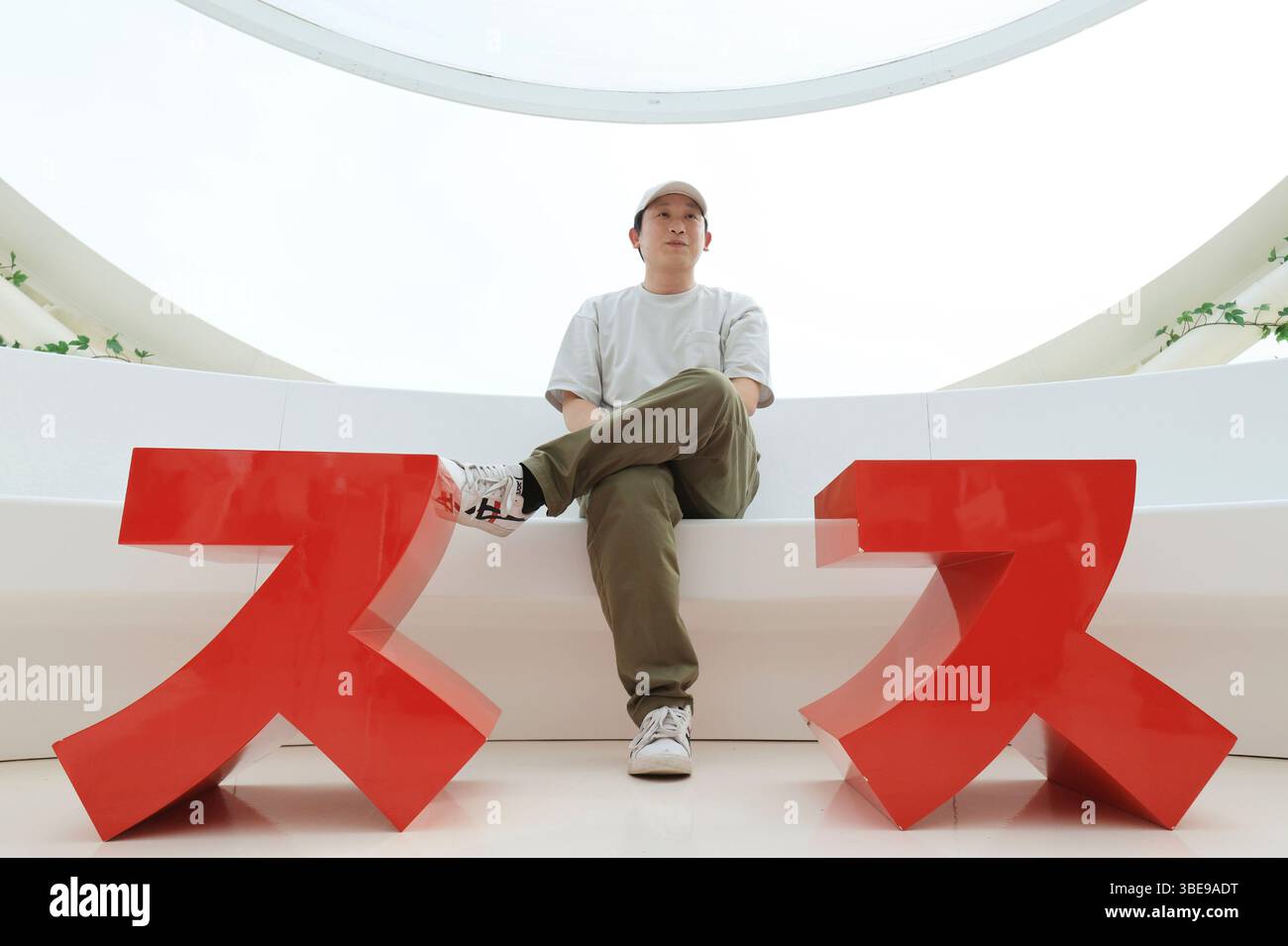 A man crosses his legs in the shape of the Japanese katakana character ...