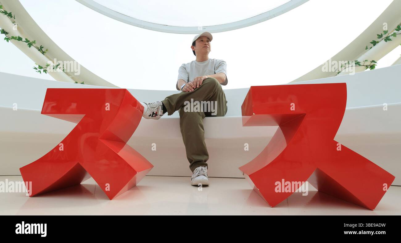 A man crosses his legs in the shape of the Japanese katakana character ...