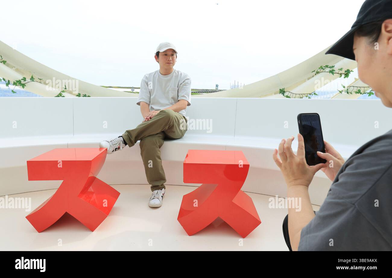 A man crosses his legs in the shape of the Japanese katakana character ...