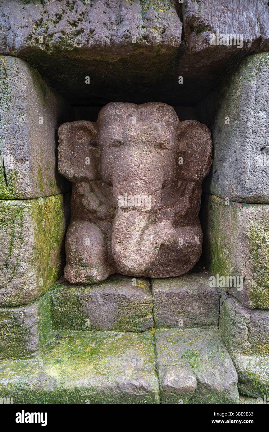 Closeup view of elephant god Ganesha laying down in niche on ancient ...