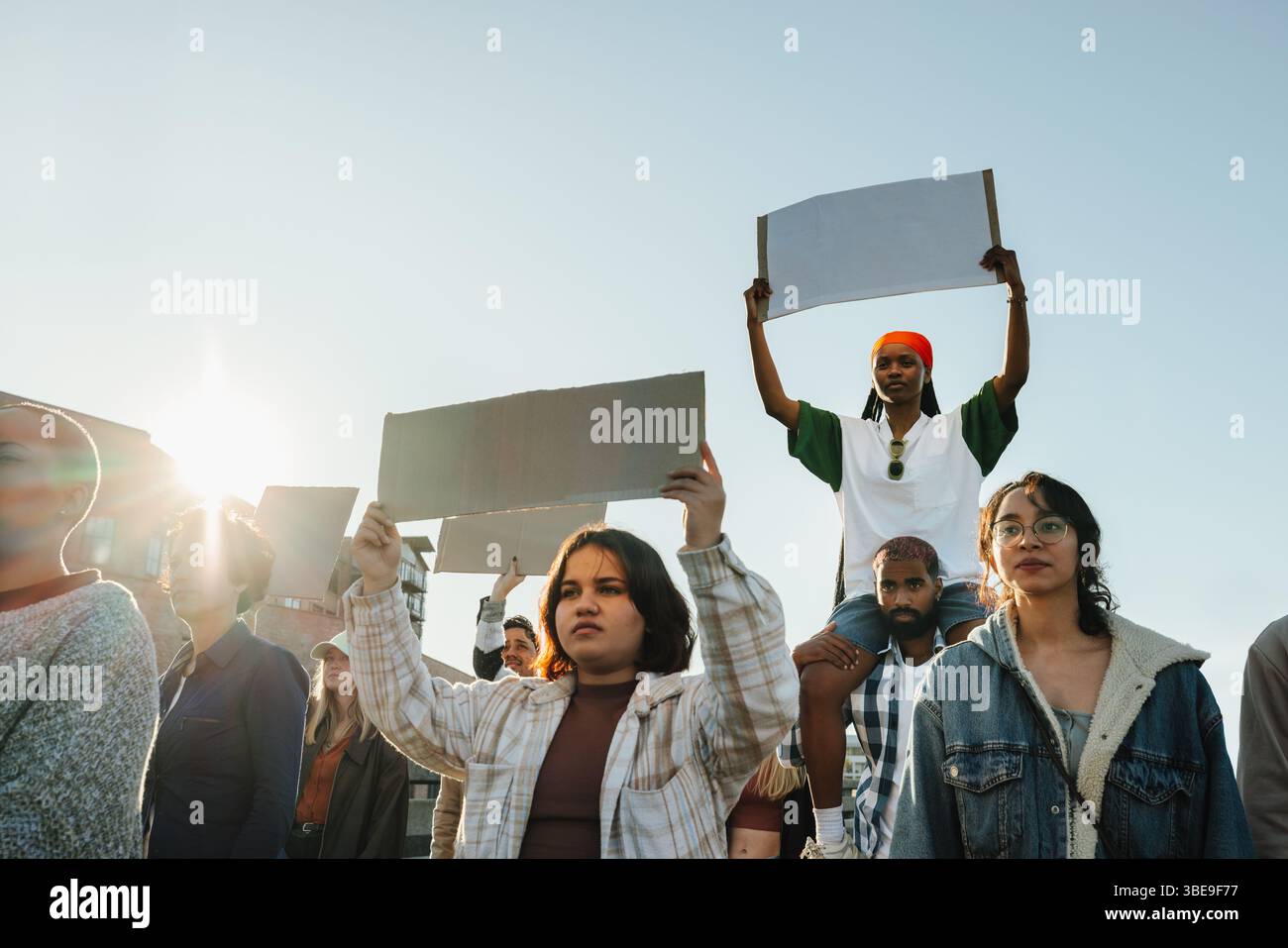 A diverse group of individuals participates in a demonstration, holding ...