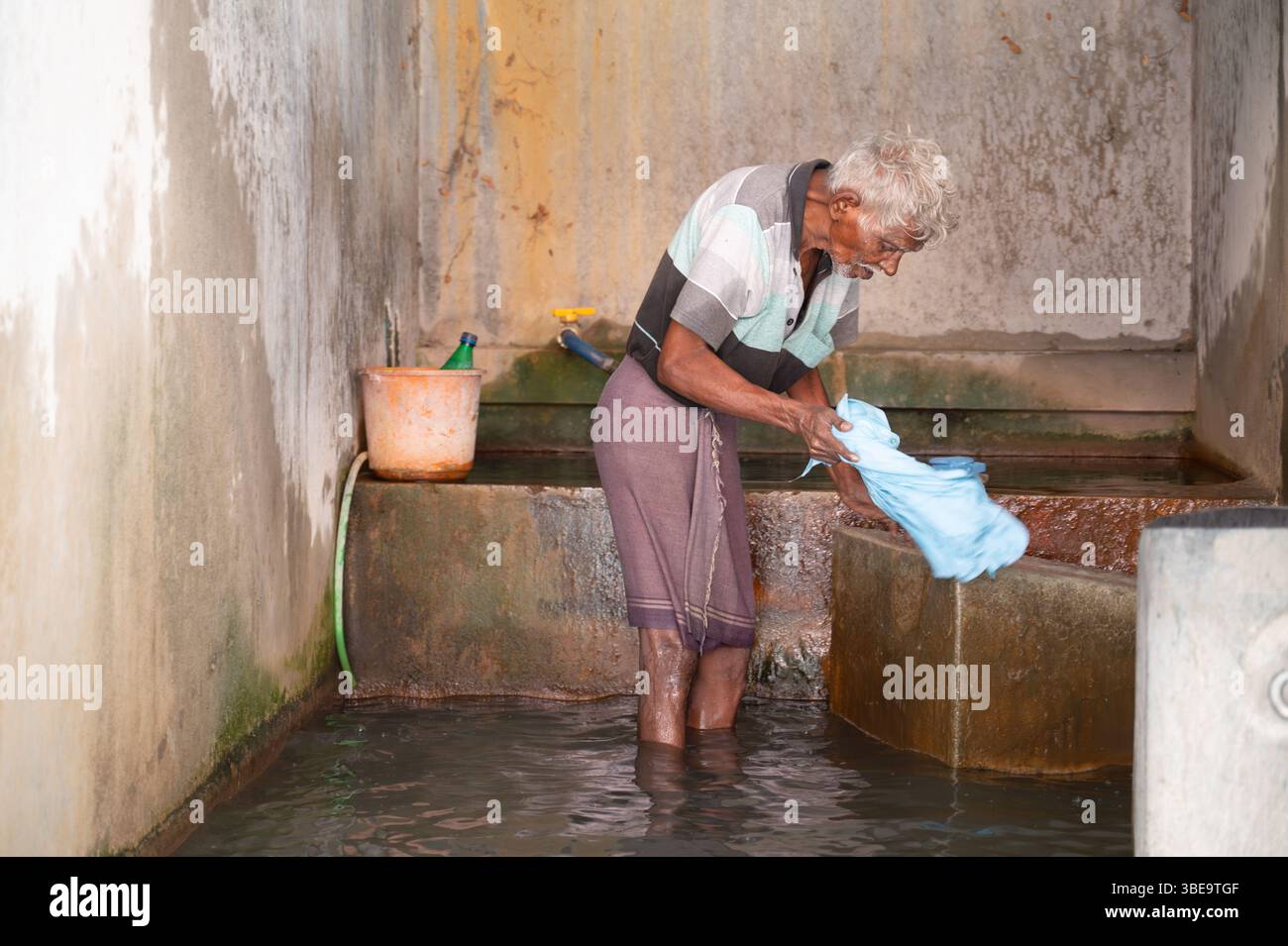 Dhobi Ghat, open air laundry in Kochi, India, man washing pile of dirty ...